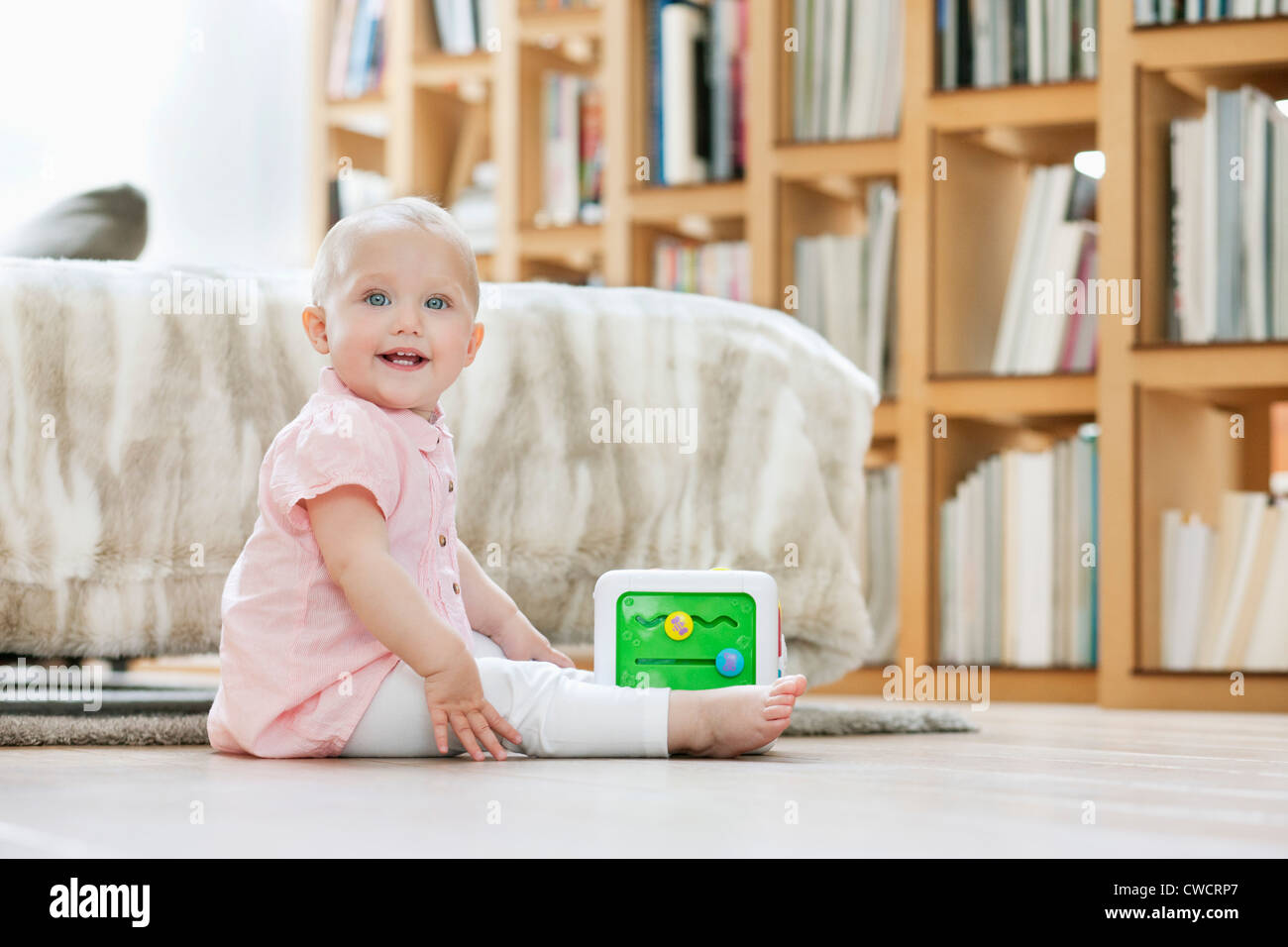 Baby girl playing with a musical block toy Stock Photo - Alamy