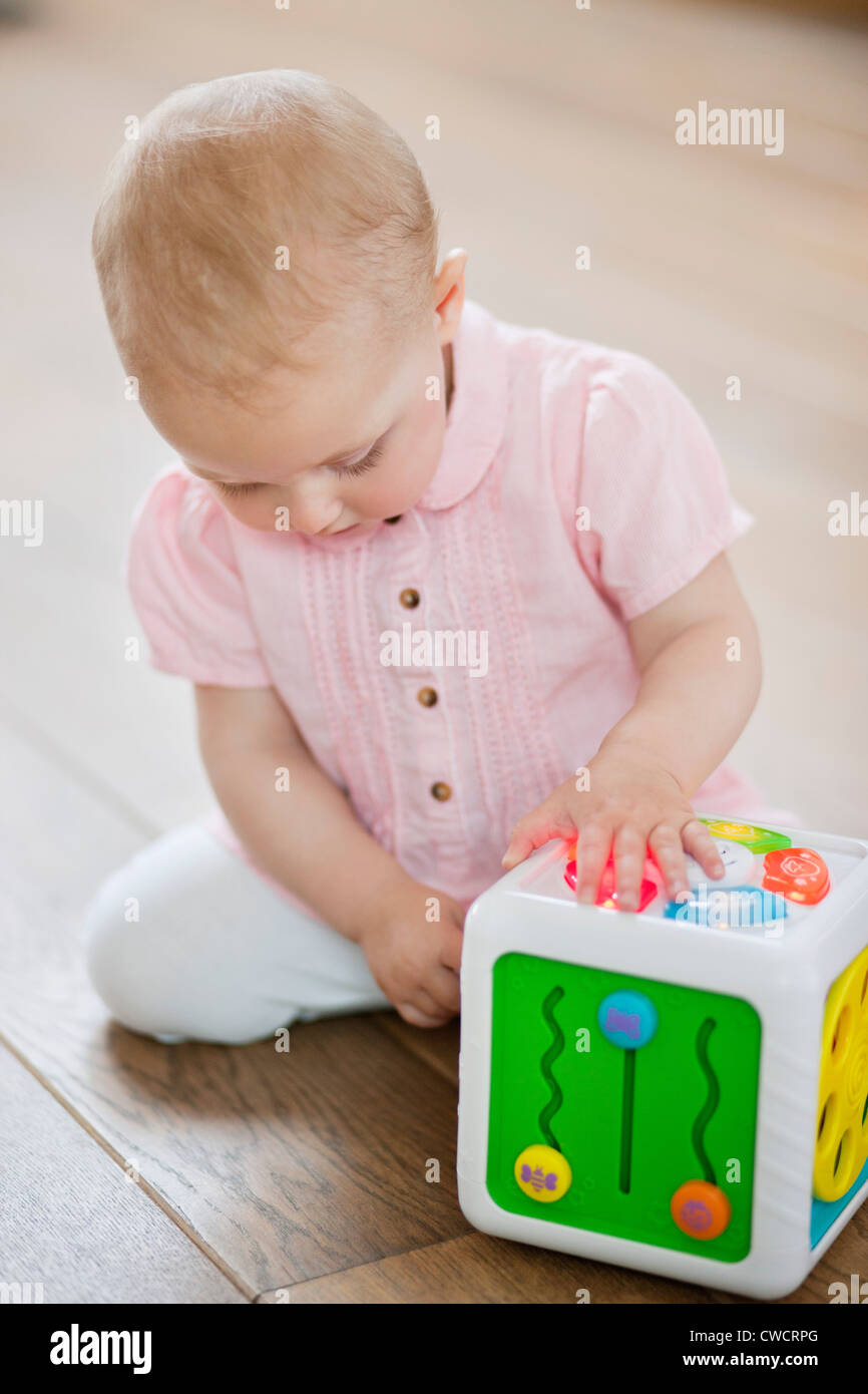 Baby girl playing with a musical block toy Stock Photo - Alamy