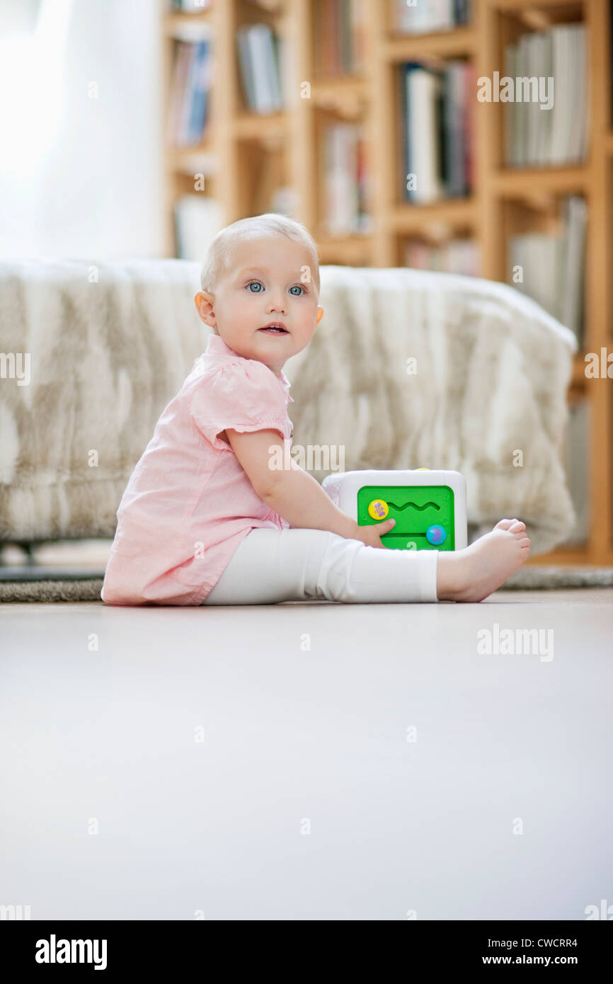 Baby girl playing with a musical block toy Stock Photo - Alamy
