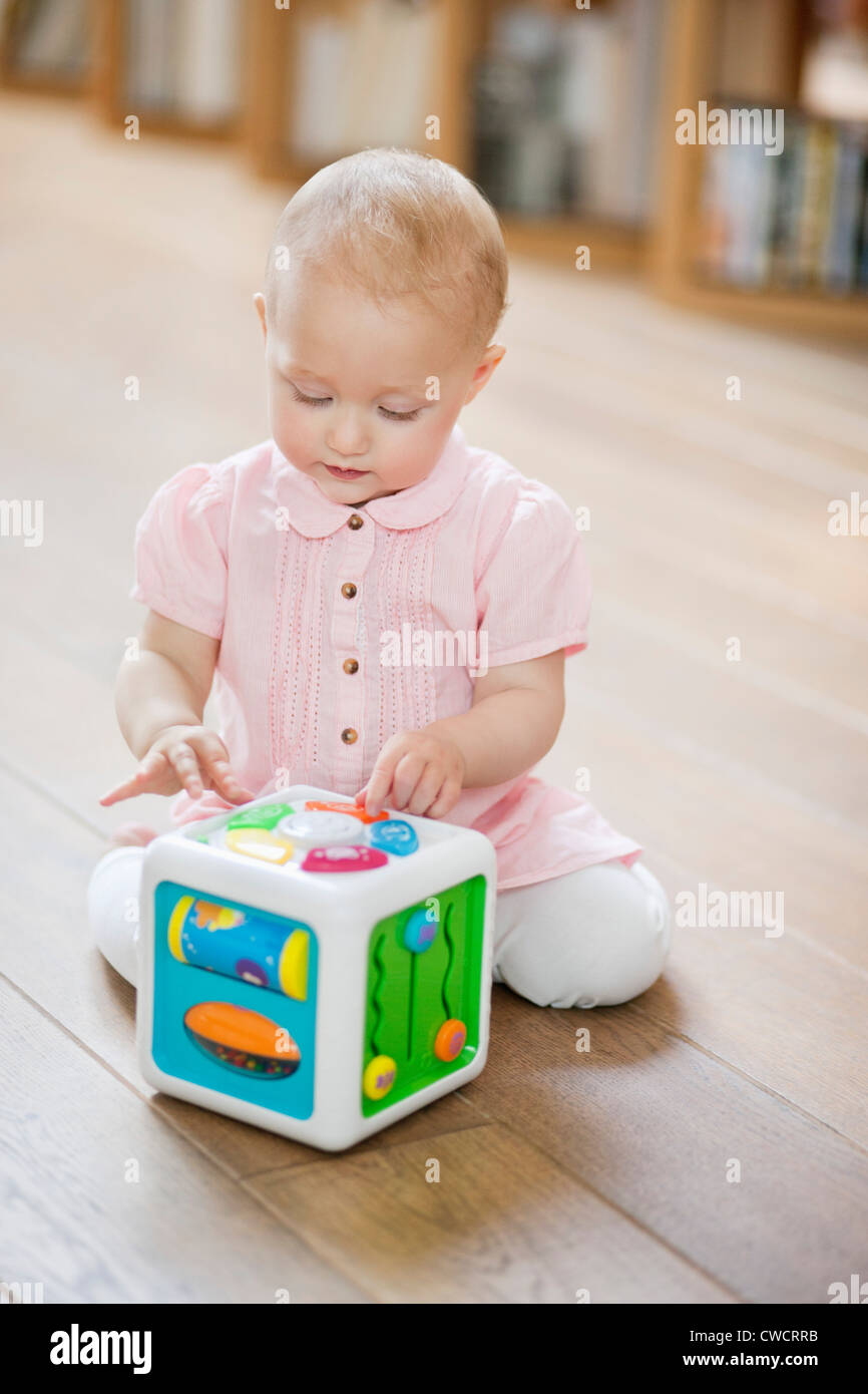 Baby girl playing with a musical block toy Stock Photo - Alamy