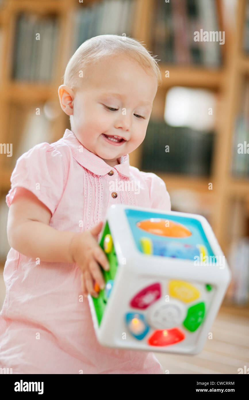 Baby girl playing with a musical block toy Stock Photo - Alamy