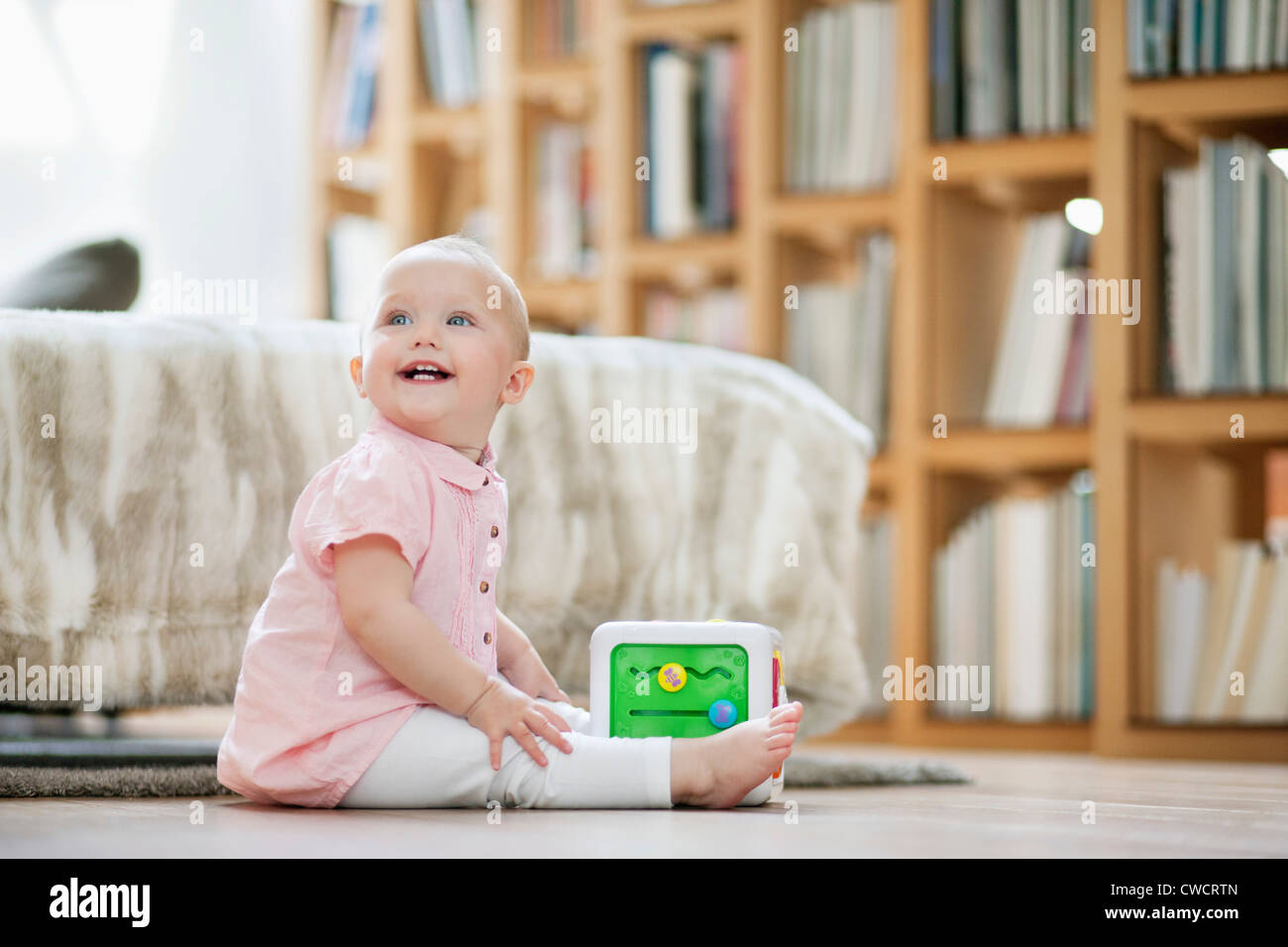 Baby girl playing with a musical block toy Stock Photo - Alamy