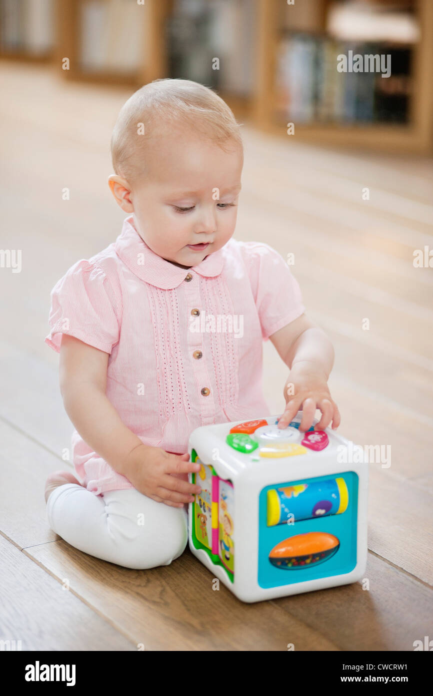 Baby girl playing with a musical block toy Stock Photo - Alamy