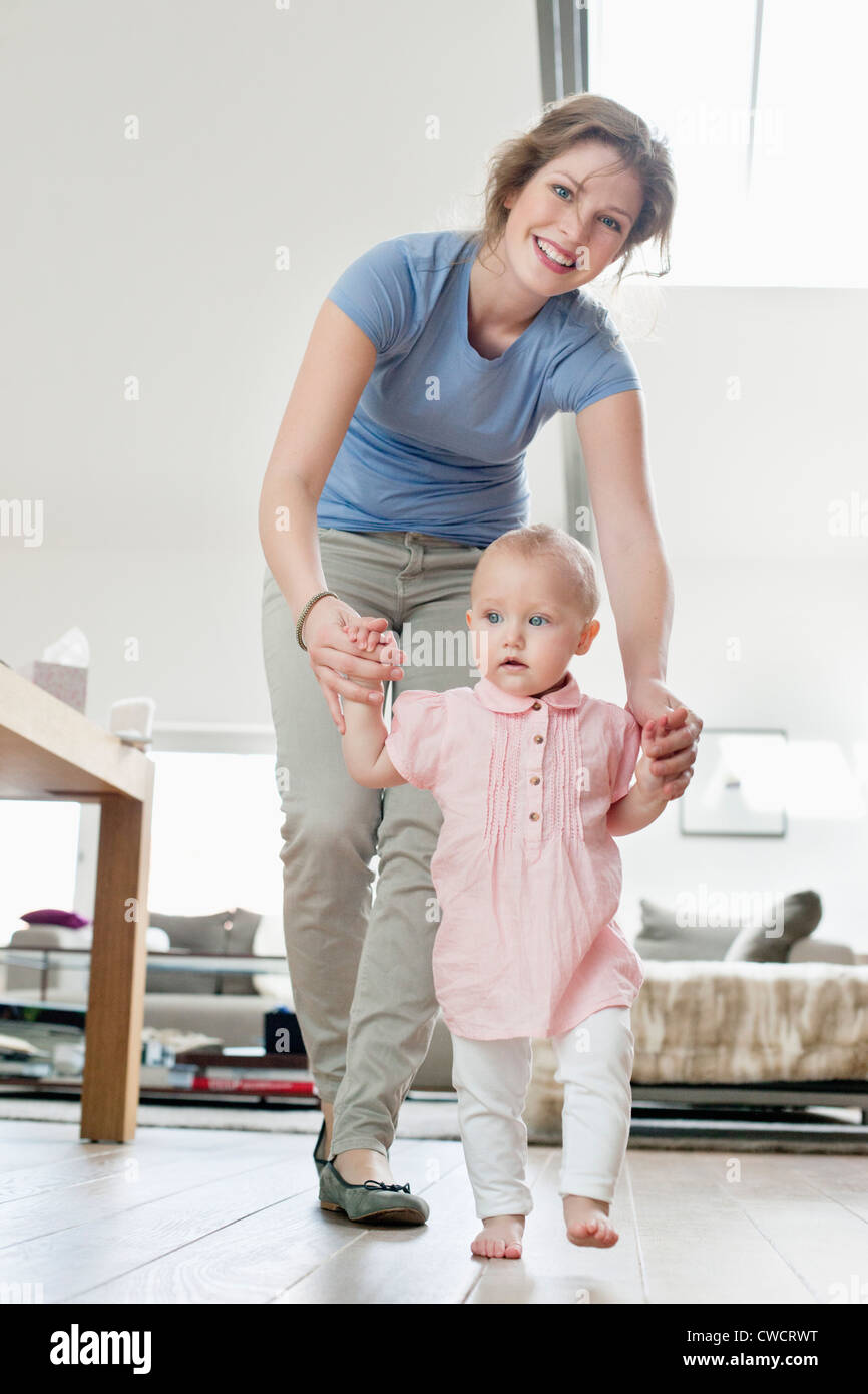 Mother helping baby to walk Stock Photo - Alamy