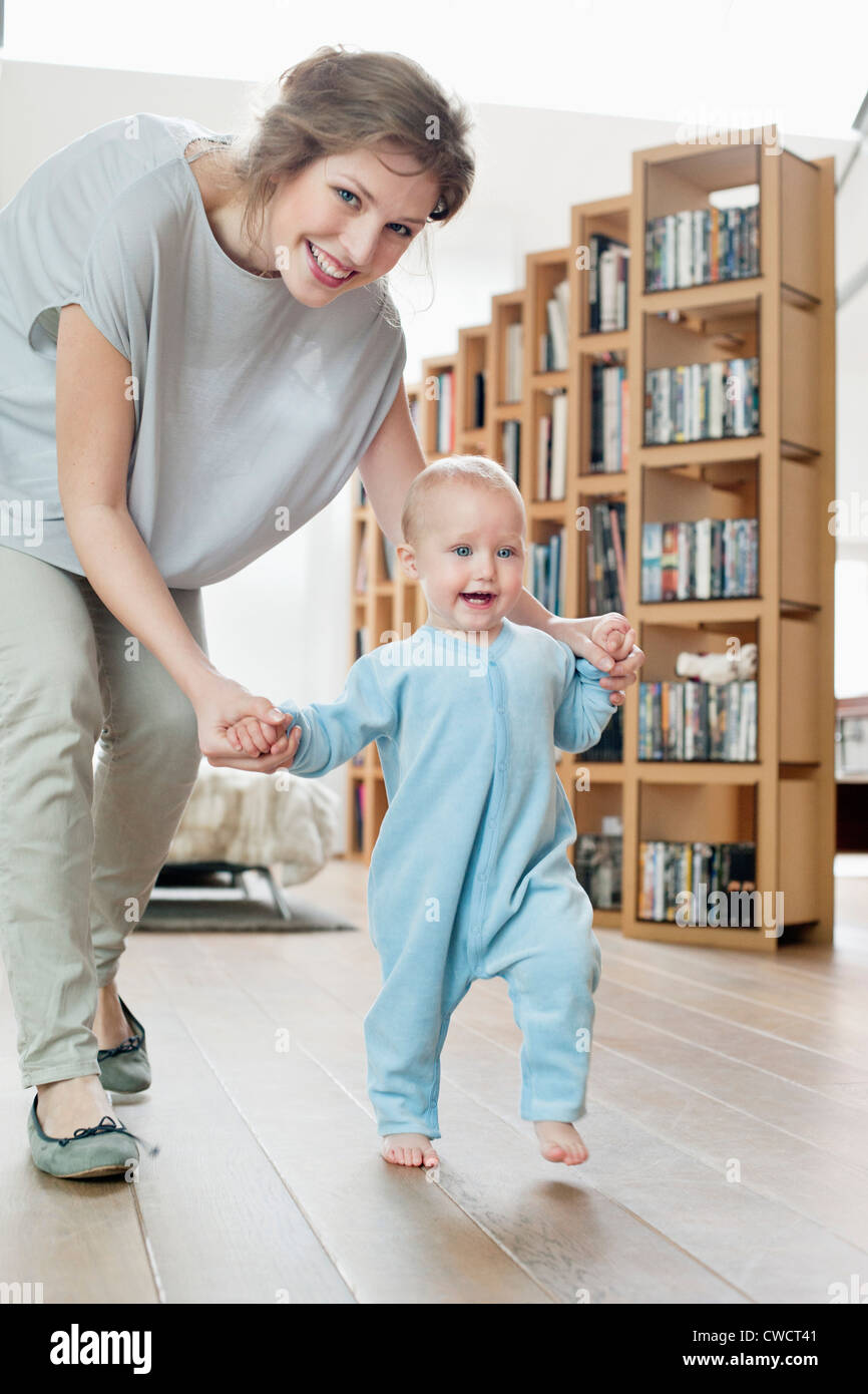 Mother helping baby to walk Stock Photo - Alamy