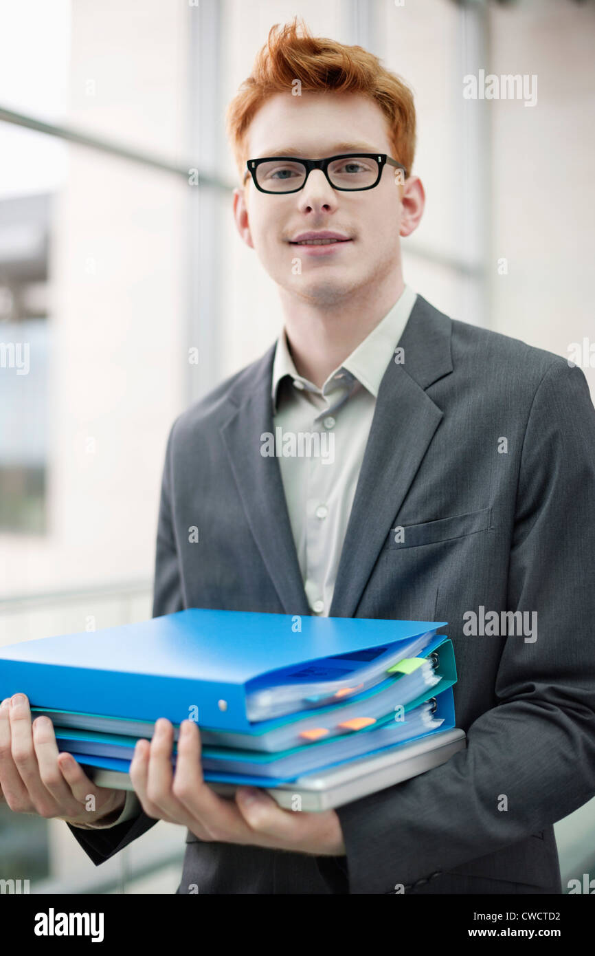 Portrait of a businessman holding files in an office Stock Photo - Alamy