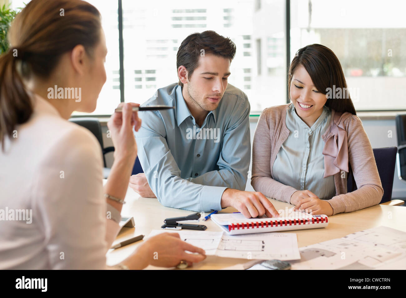 Real estate agent discussing property documents to his clients Stock ...