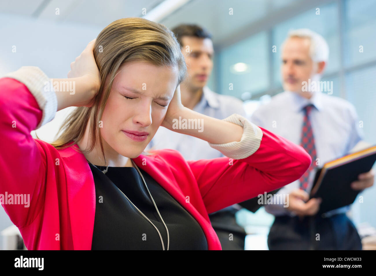 Female executive looking frustrated in an office with her colleagues ...