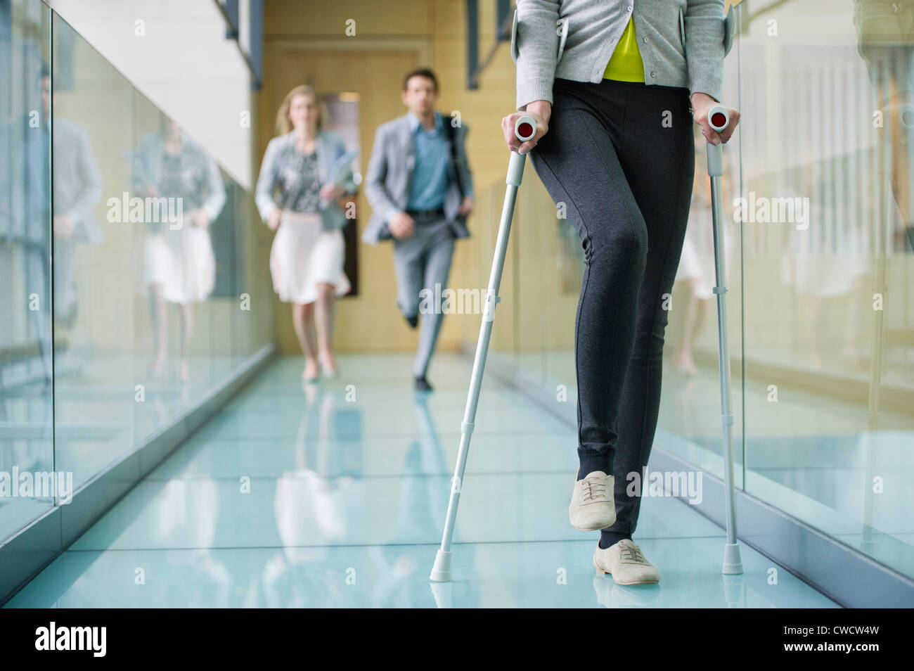 Disabled woman walking with a man and a woman running behind her Stock ...