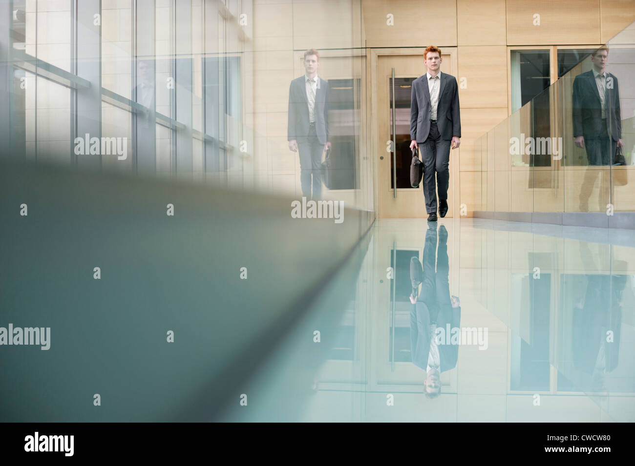 Businessman walking in an office corridor Stock Photo - Alamy