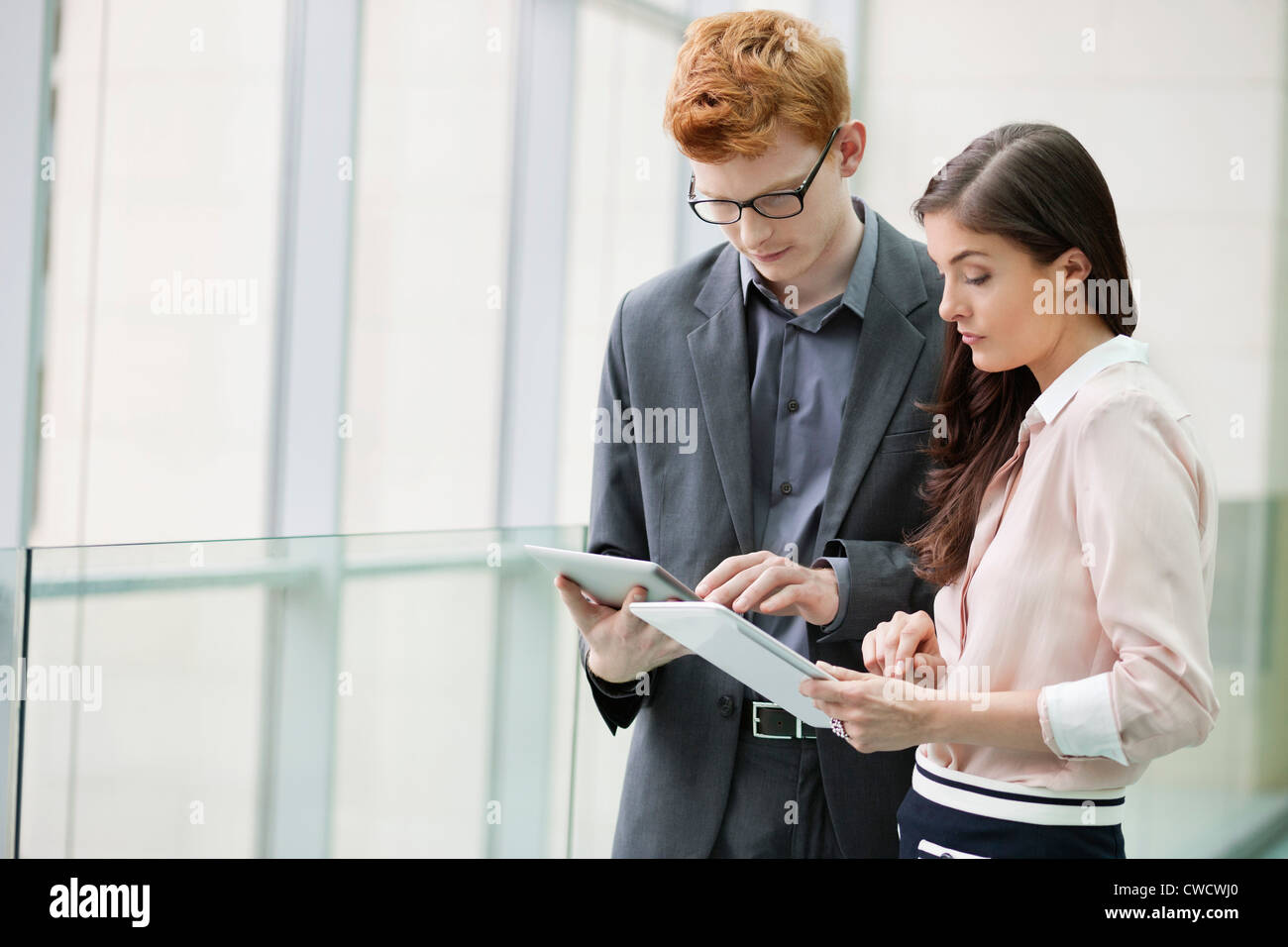 Business executives using digital tablets in an office Stock Photo - Alamy