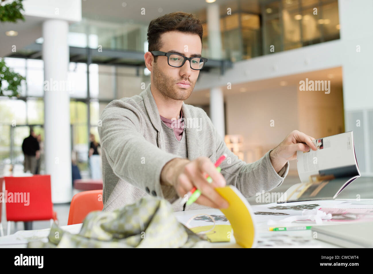 Male fashion designer working in an office Stock Photo - Alamy