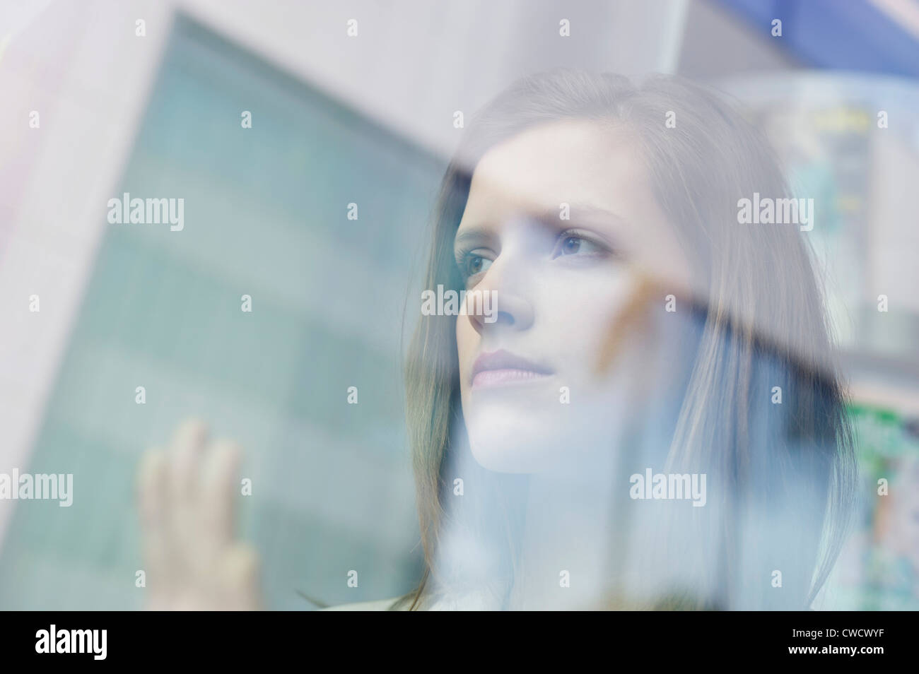 Businesswoman looking through the glass of a window Stock Photo - Alamy