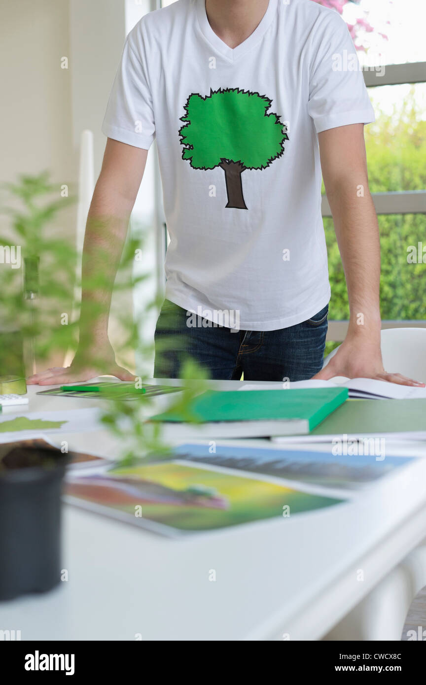 Plant and environmental awareness poster on a table in front of a man ...