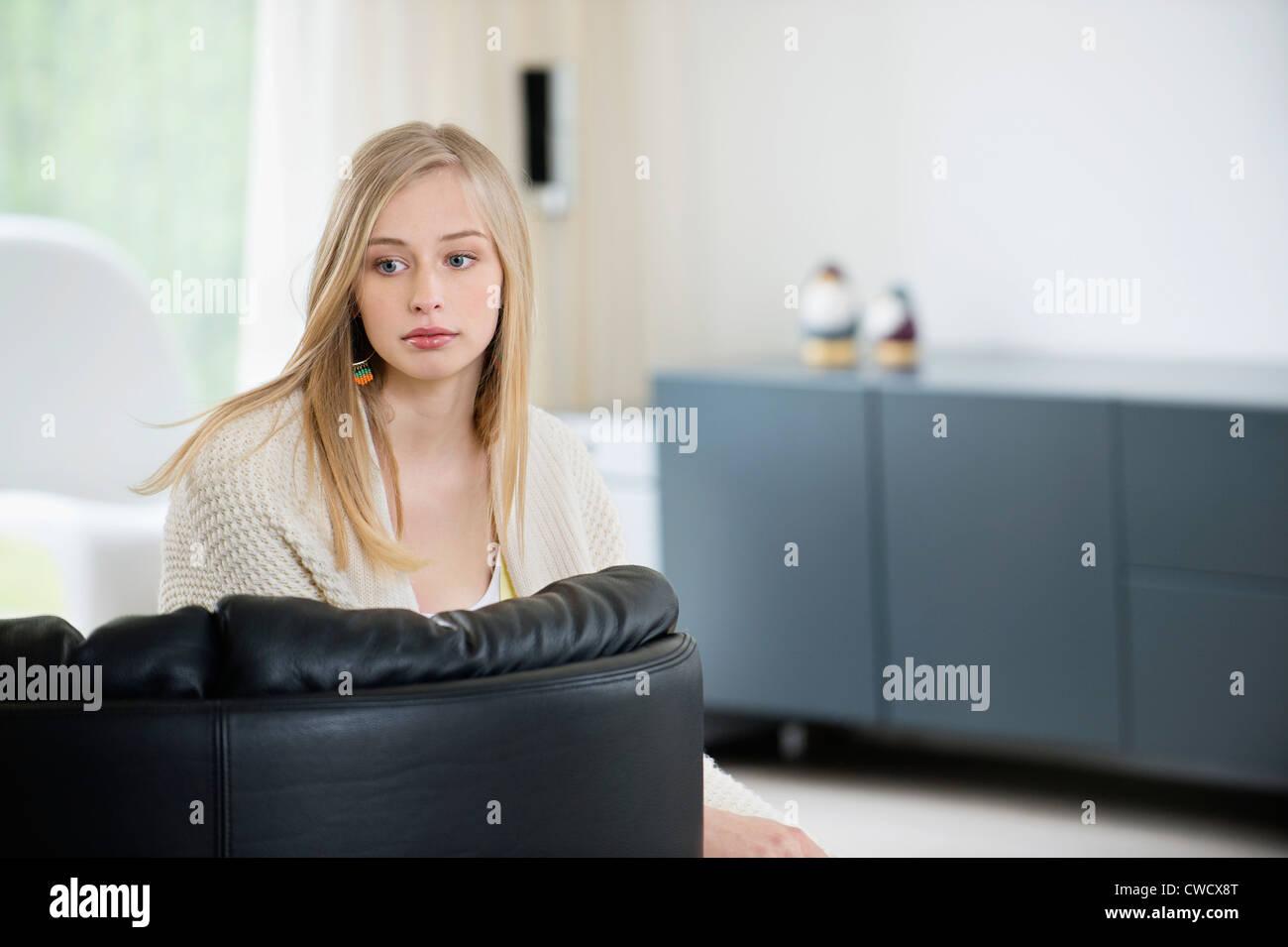Serious woman sitting in a room Stock Photo - Alamy