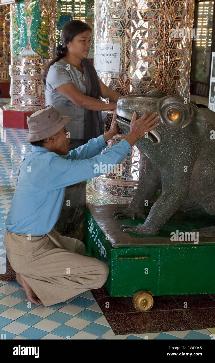 Myanmar, Burma. Burmese Man Venerating Frog Sculpture in Buddhist ...