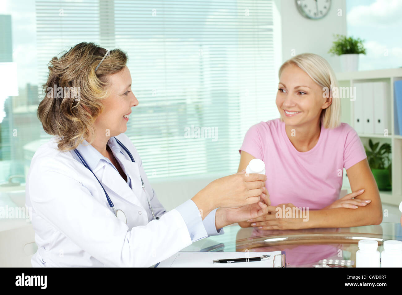 Portrait of confident practitioner prescribing vitamins to patient in ...