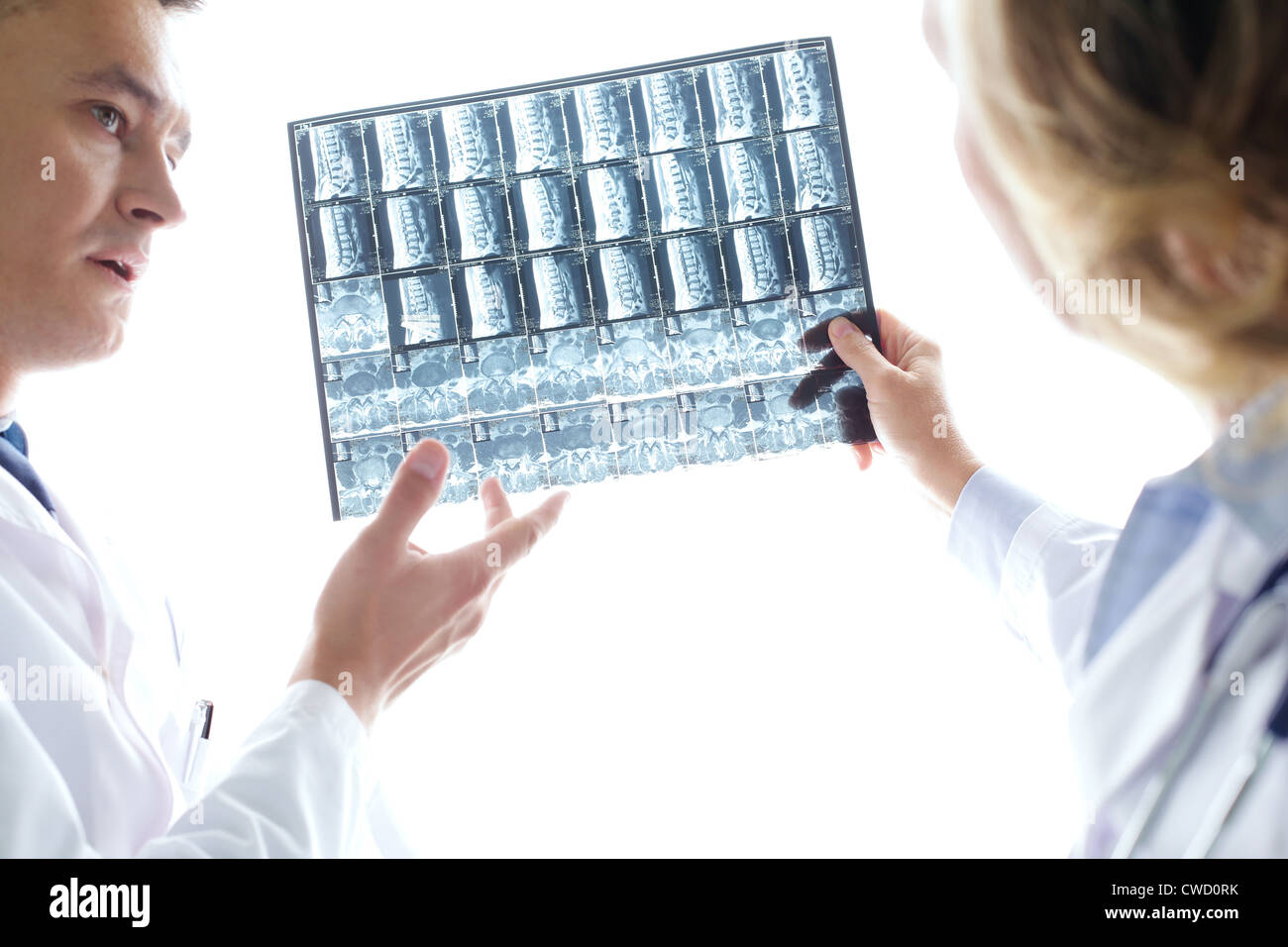 Portrait of young doctor showing and interpreting x-ray samples to ...