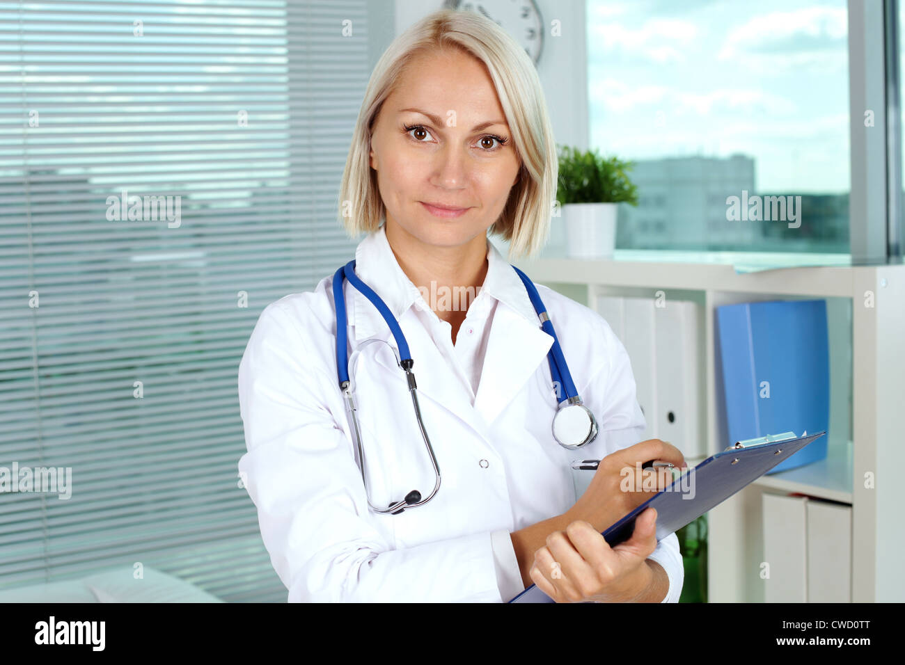 Portrait of pretty female practitioner looking at camera in hospital ...