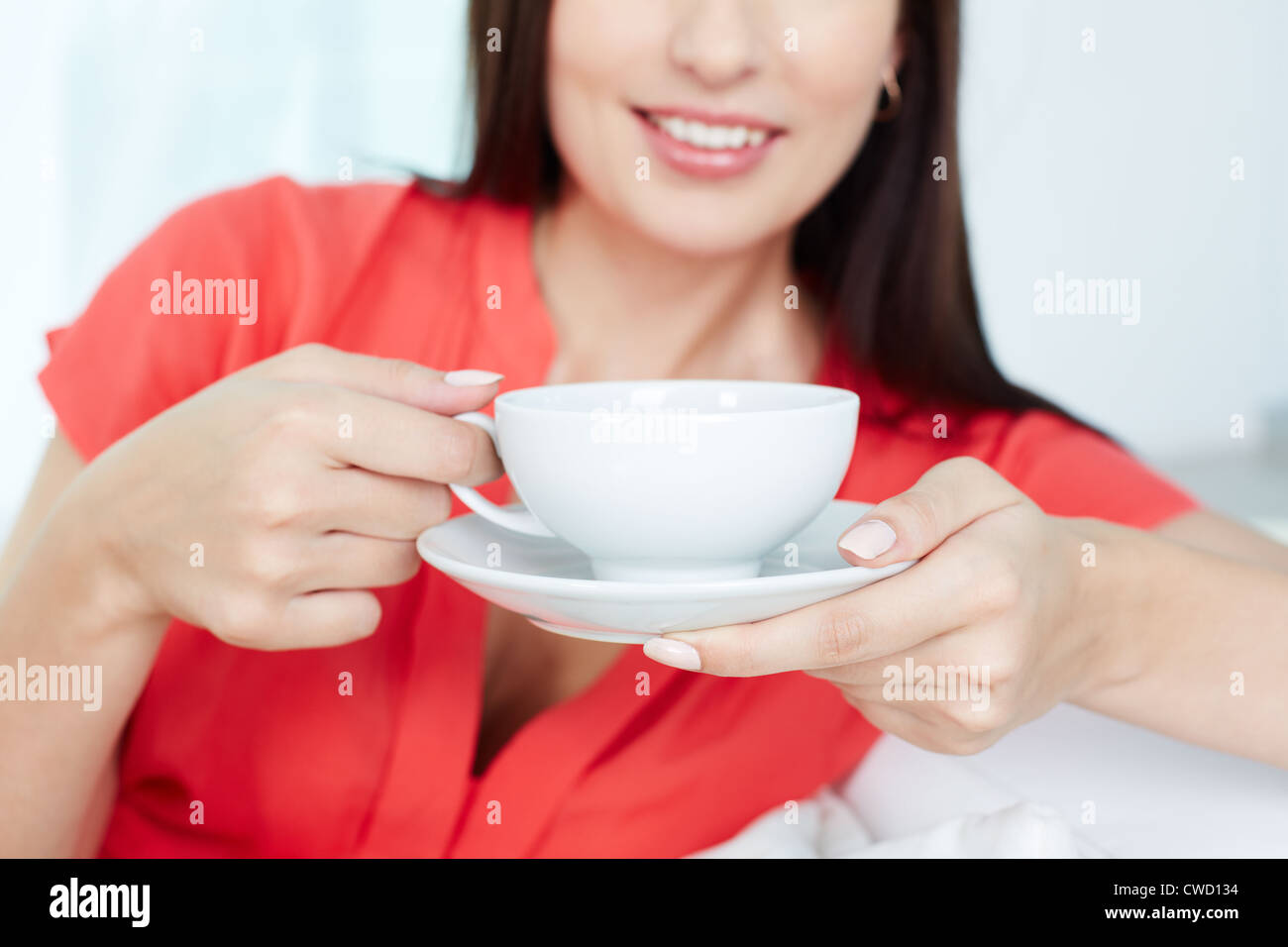 Young girl holding cup and smiling Stock Photo - Alamy