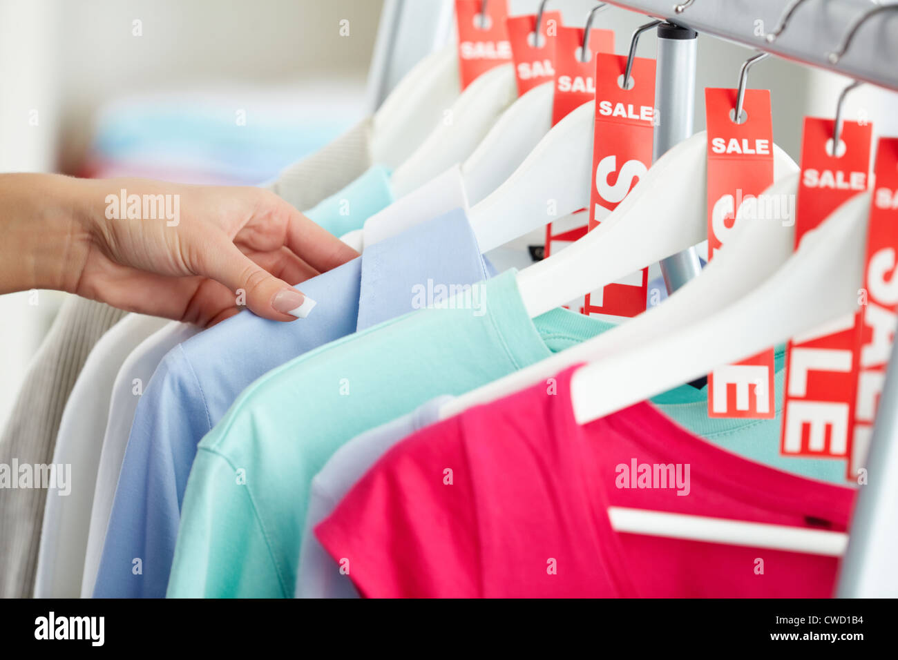 Photo of human hand searching through hangers with clothes Stock Photo ...