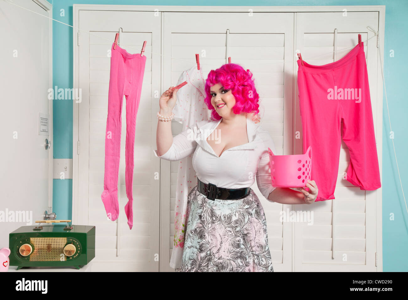 Portrait of a happy woman showing clothespin Stock Photo - Alamy