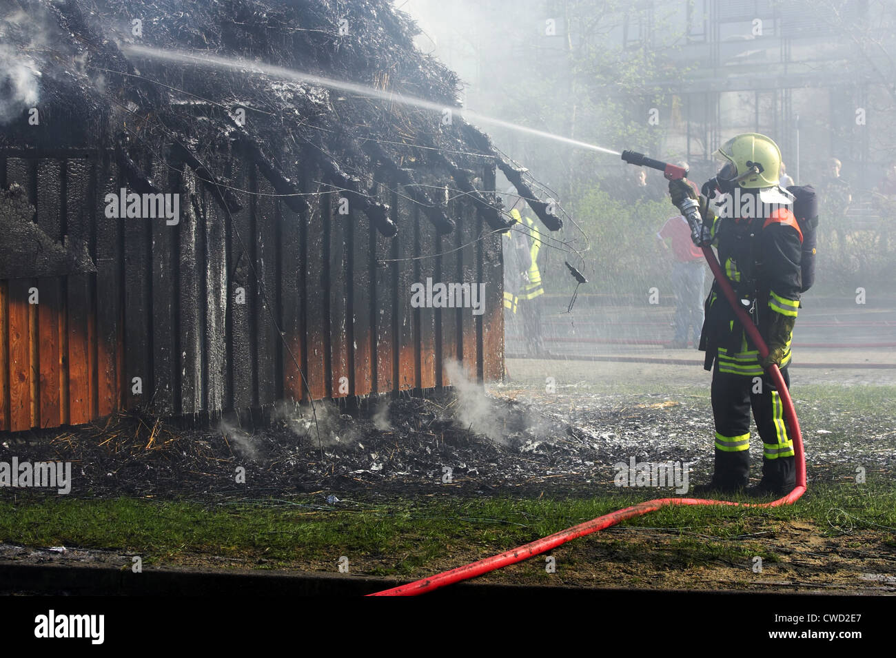 Firefighters, fire and thatched Stock Photo - Alamy