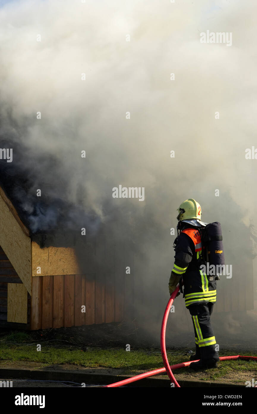 Firefighters, fire and thatched Stock Photo - Alamy
