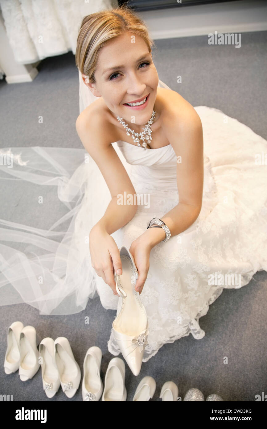 Portrait of a happy beautiful woman in wedding dress sitting with ...