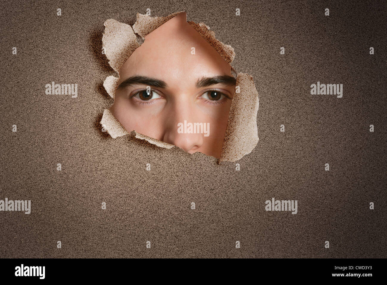 Portrait of a young Caucasian man peeking from ripped paper hole Stock ...