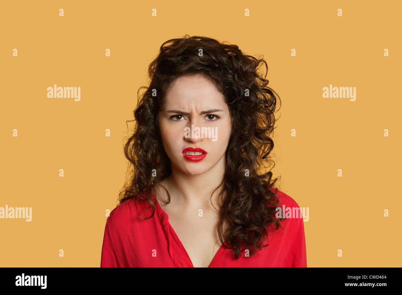 Portrait of angry young woman frowning over colored background Stock ...