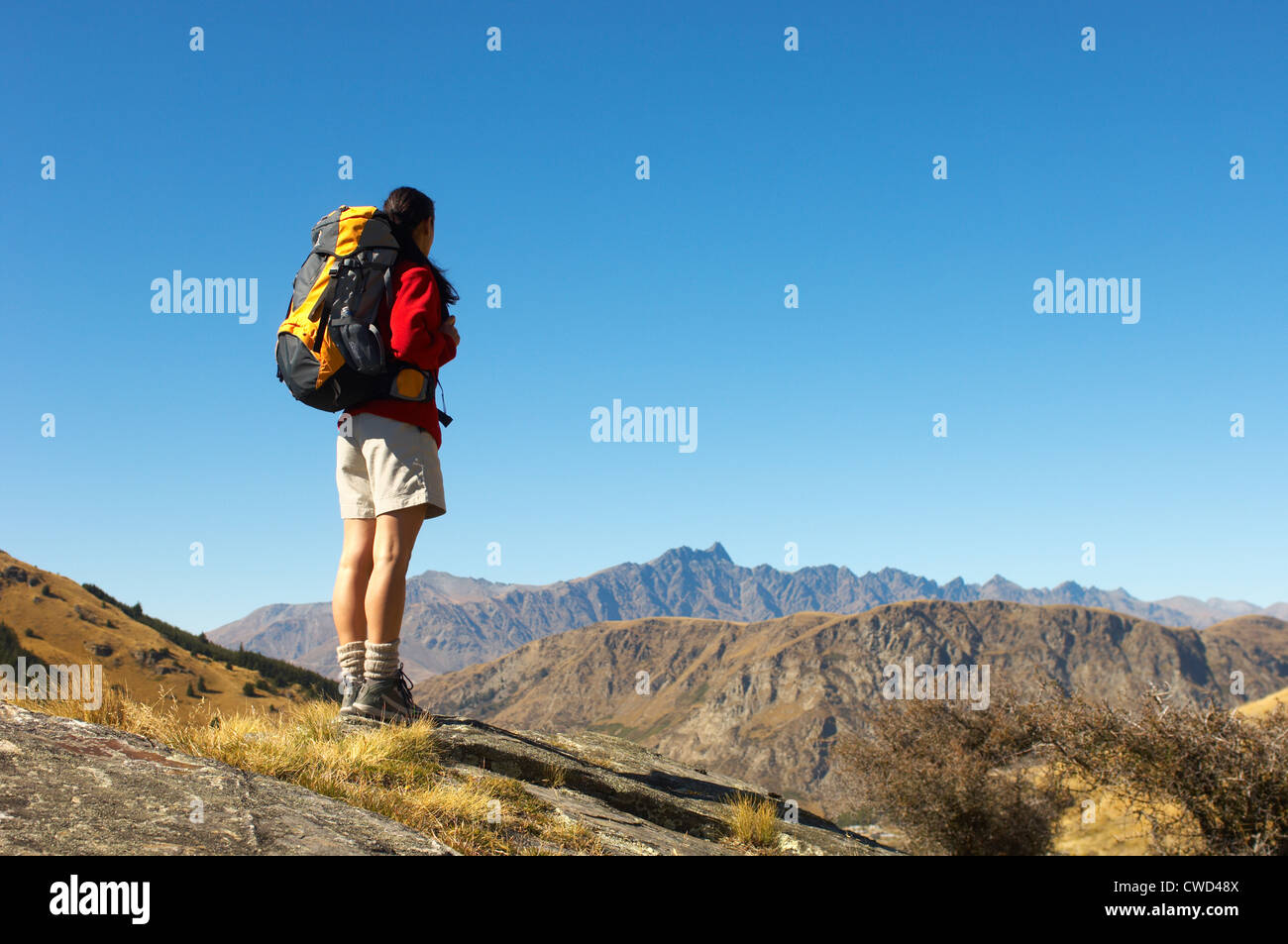 Young woman hiking, view from Moonlight Track towards The Remarkables ...