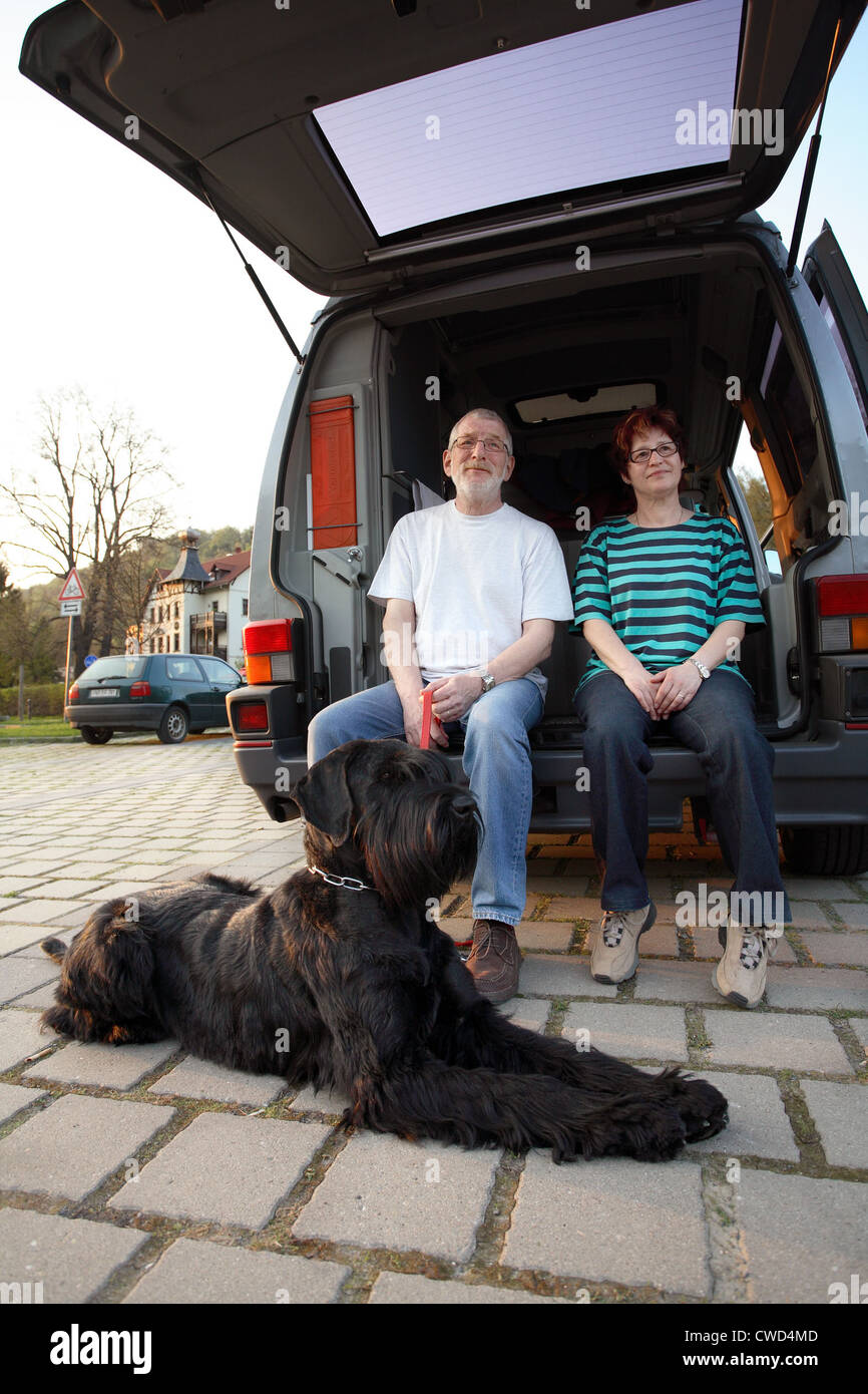 Couple with a large dog and minibus Stock Photo - Alamy