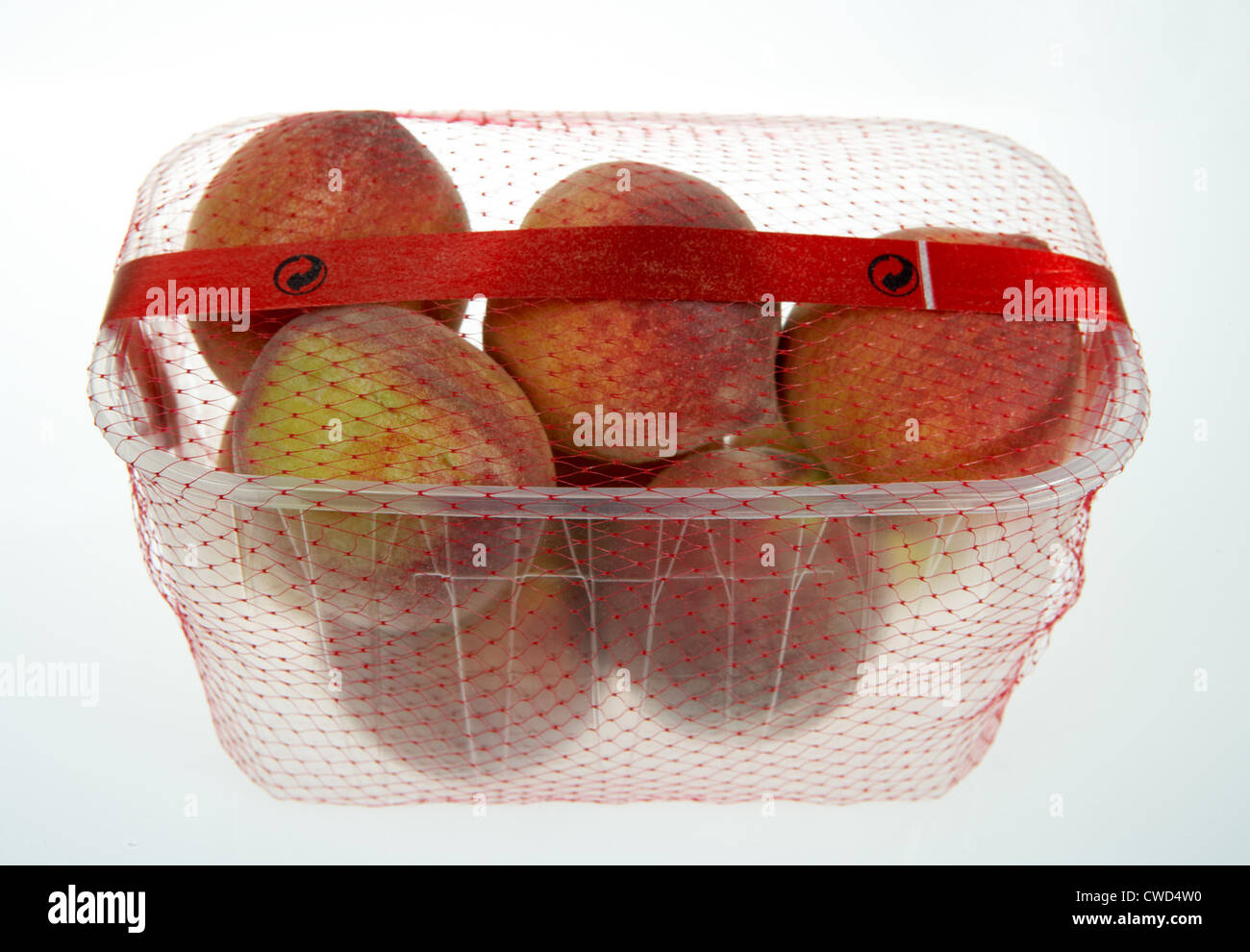 Spanish peaches in a plastic container frame covered by a red net Stock ...