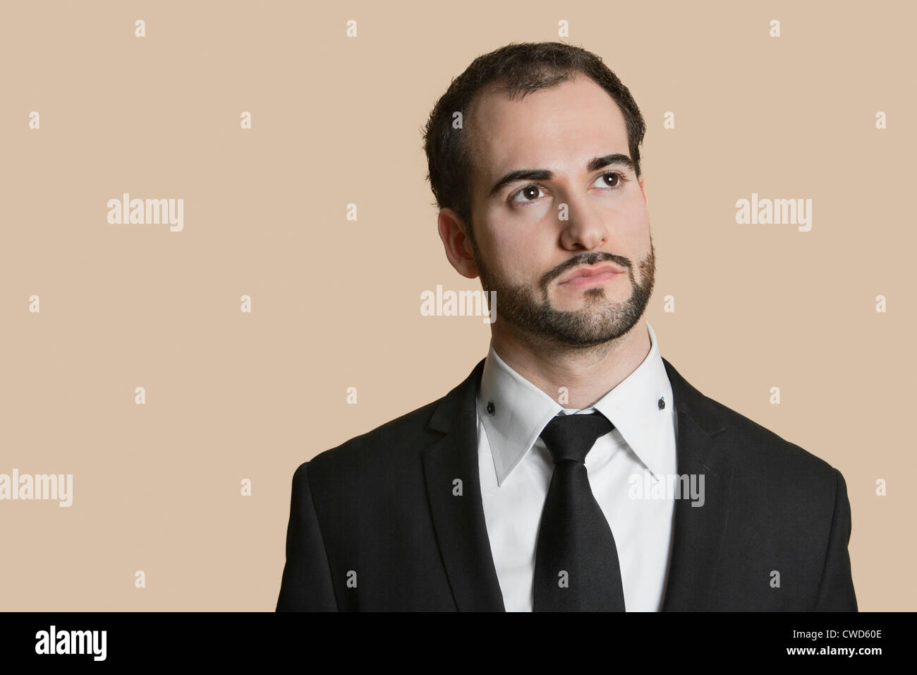 Young businessman looking away over colored background Stock Photo - Alamy