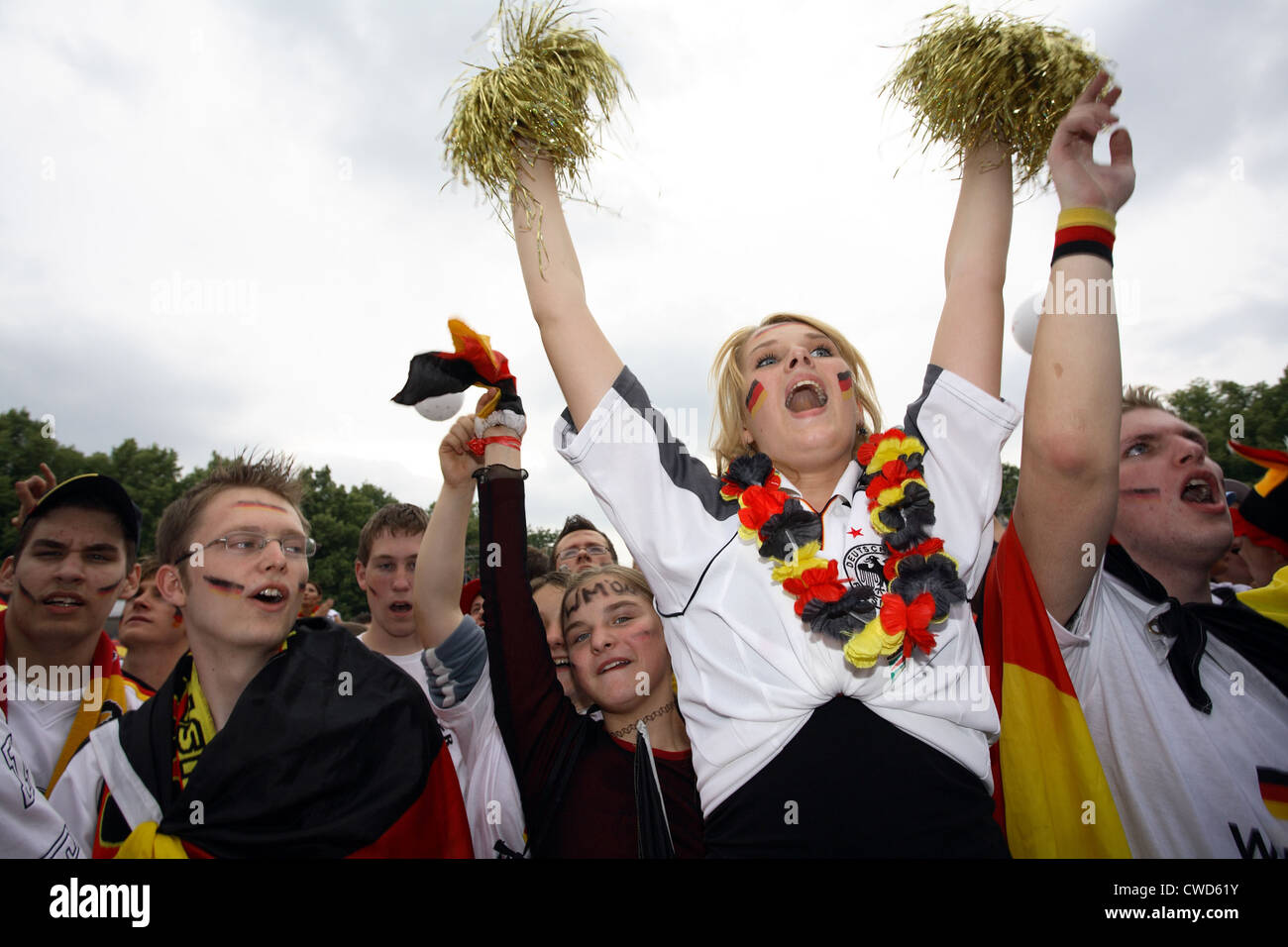 Berlin, German football fans World Cup 2006: Woman cheering between men ...