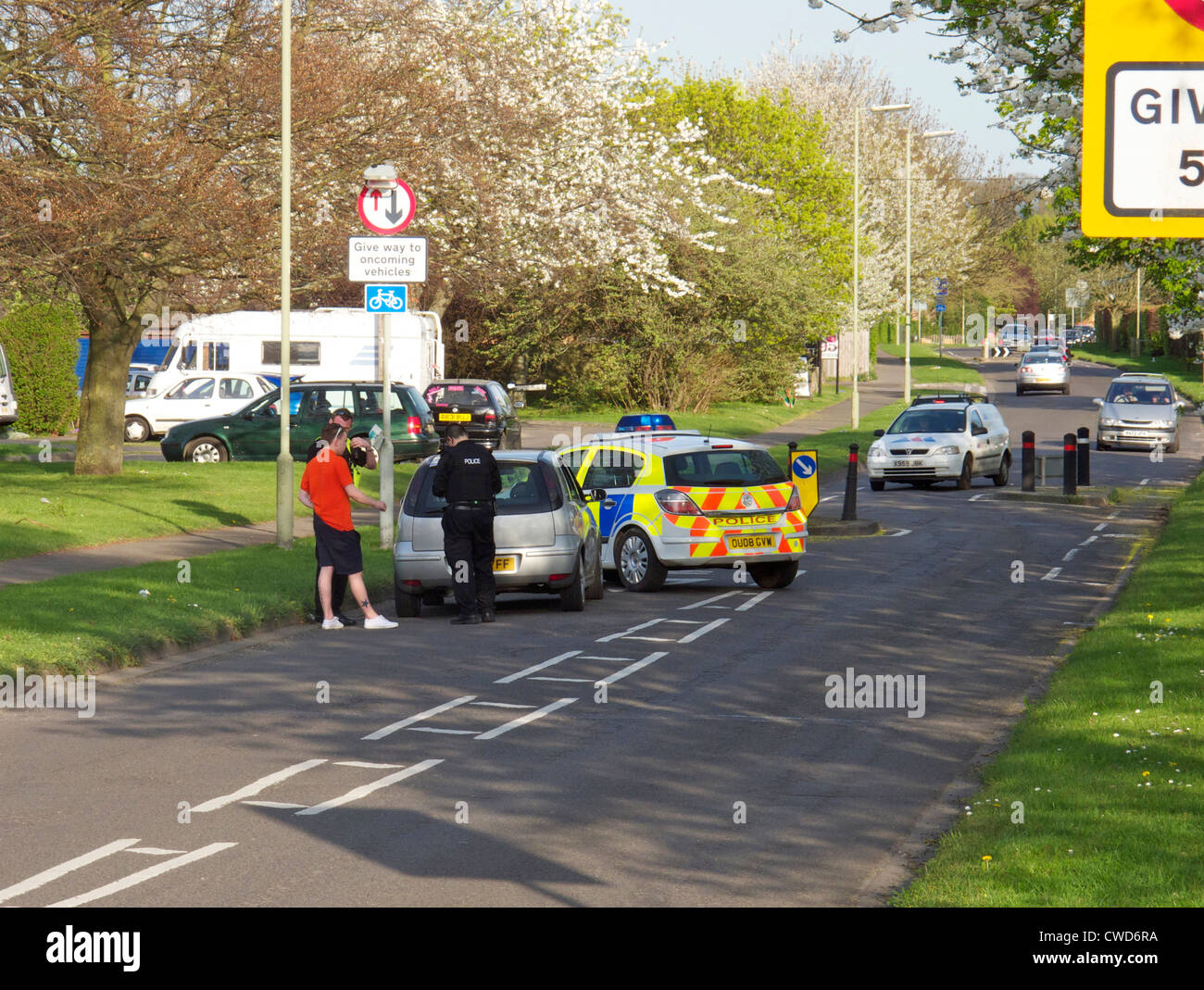 Police stop car on a local road near a traffic calming scheme and speak ...