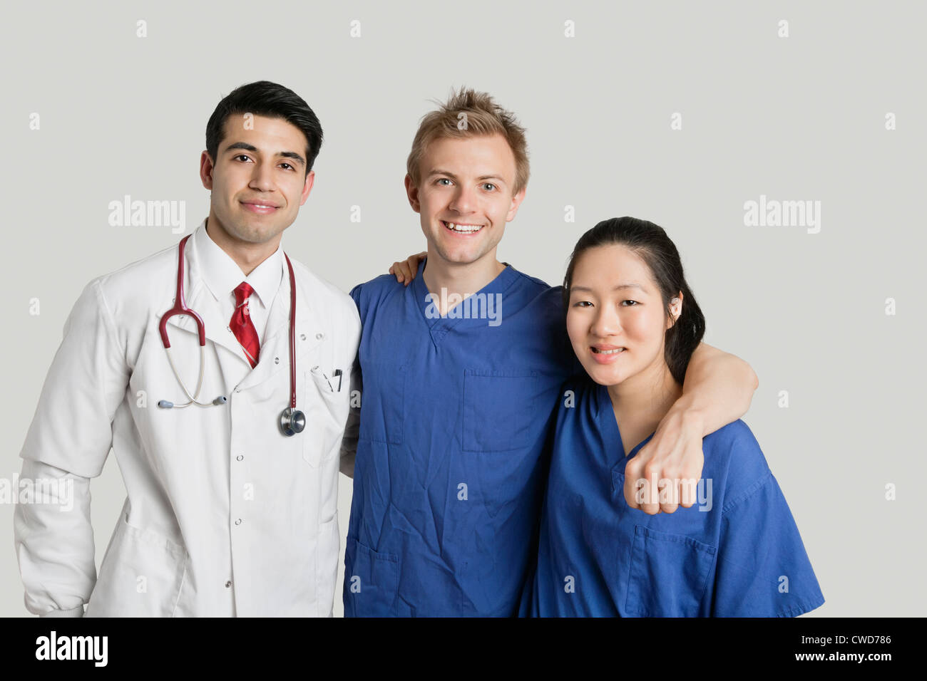 Portrait of friendly medical team standing over gray background Stock ...