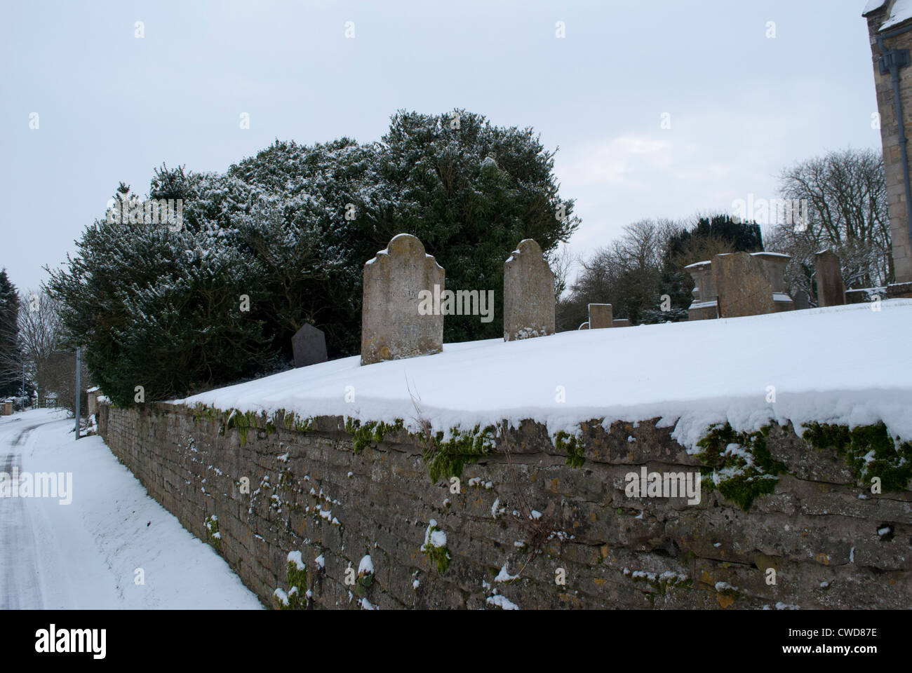 Snow covered graveyard with stone retaining wall Stock Photo - Alamy