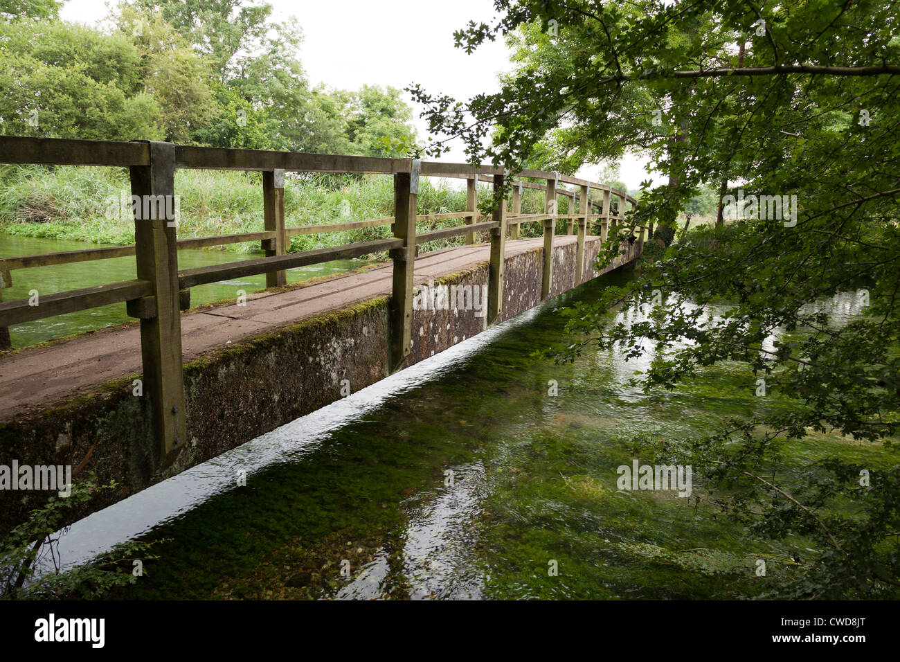 narrow concrete footbridge with wooden hand rails over the river itchen ...