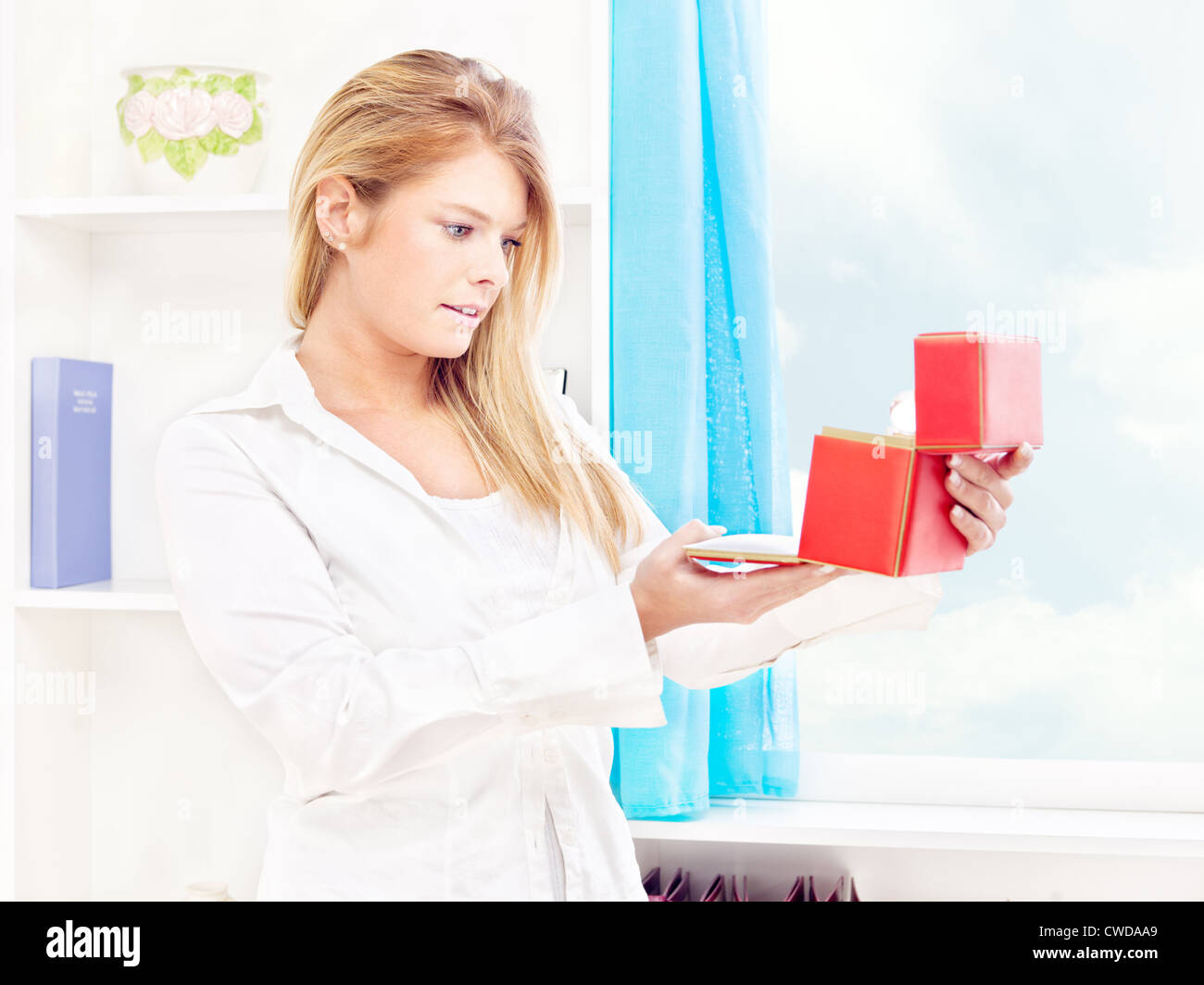 Blond woman opening fancy box at home Stock Photo - Alamy