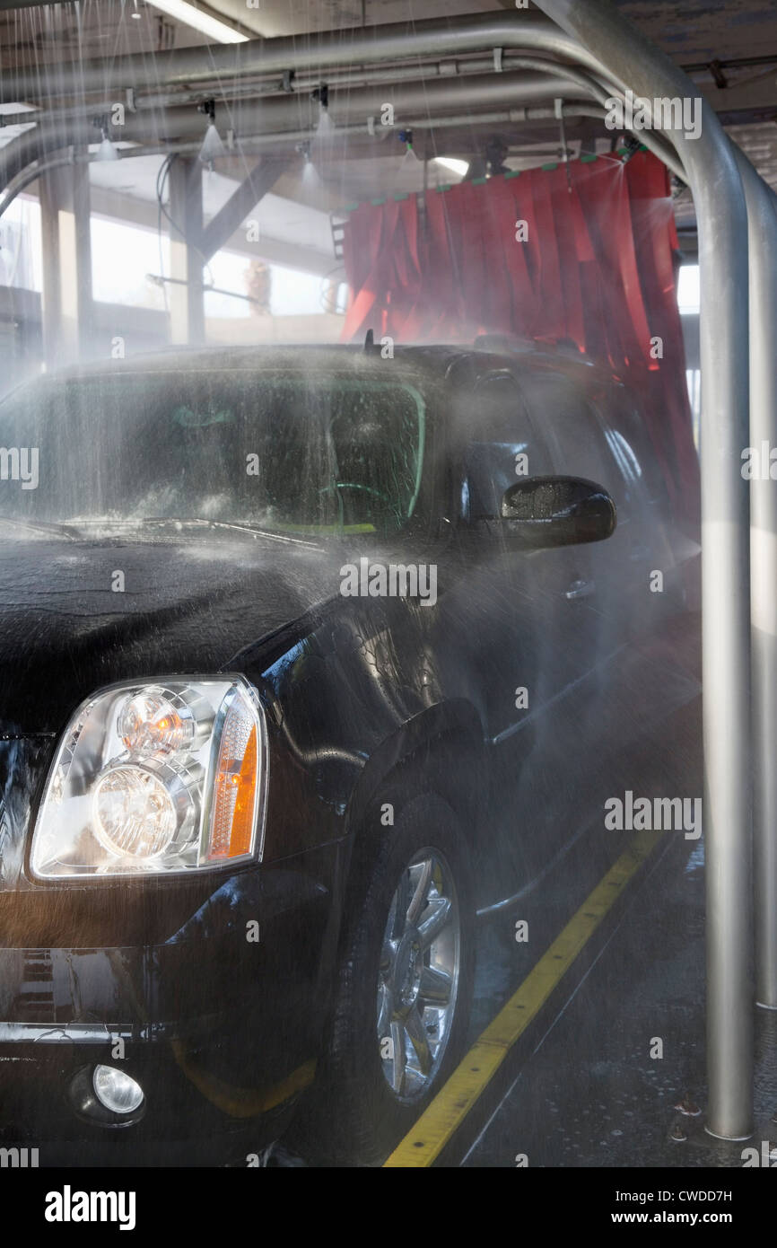 Spraying water on automobile in car wash Stock Photo - Alamy