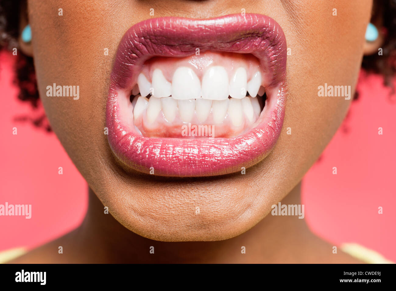 Cropped image of woman clenching teeth Stock Photo - Alamy