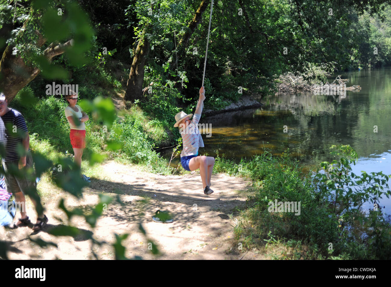 Family having fun on a rope by the river in the Lot Region of South ...