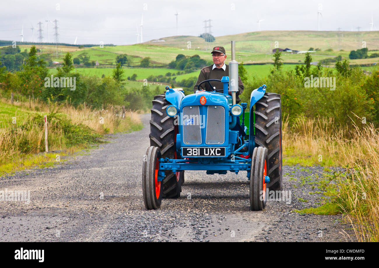 Enthusiast driving a blue vintage Fordson Power Major tractor during an ...