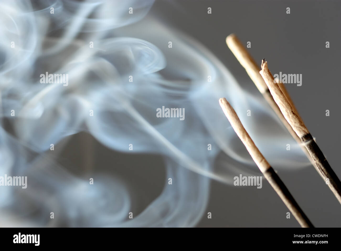 Smoke coming up from an incense stick over a gray background Stock ...