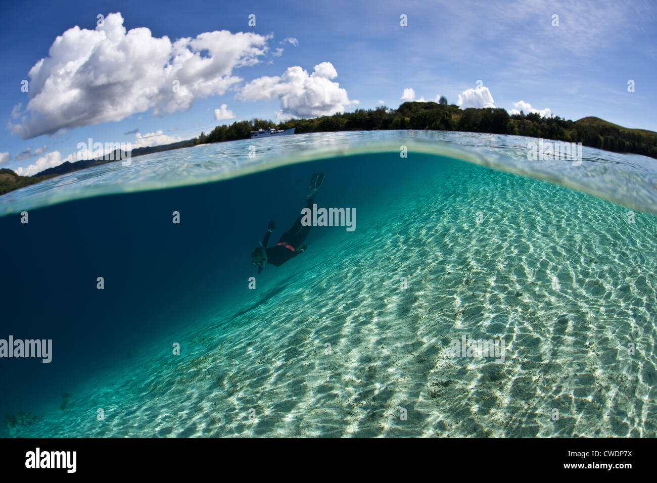A freediver descends along the edge of a sandy slope. Florida Islands ...