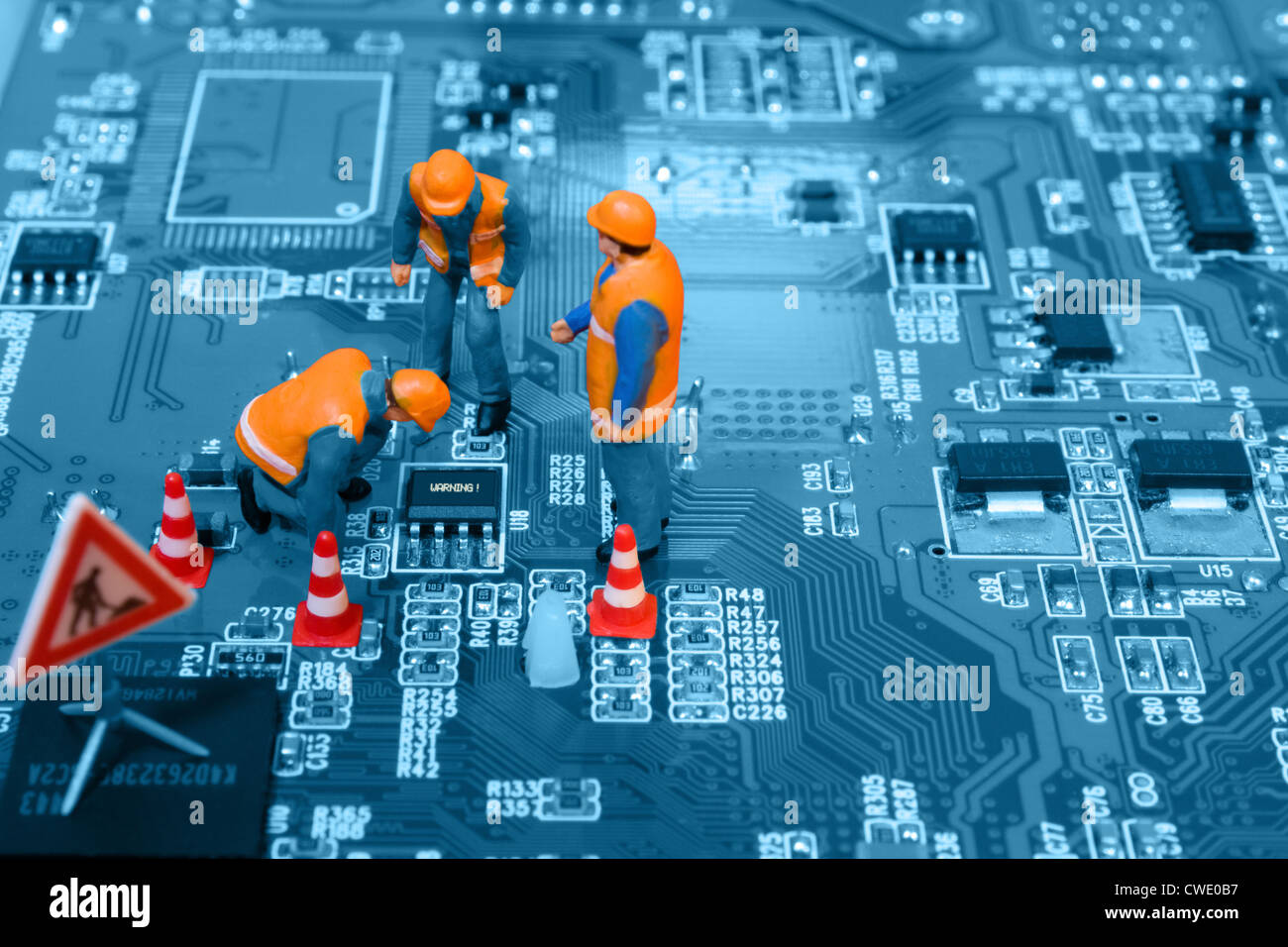 Miniature engineers fixing error on chip of circuit board. Computer ...
