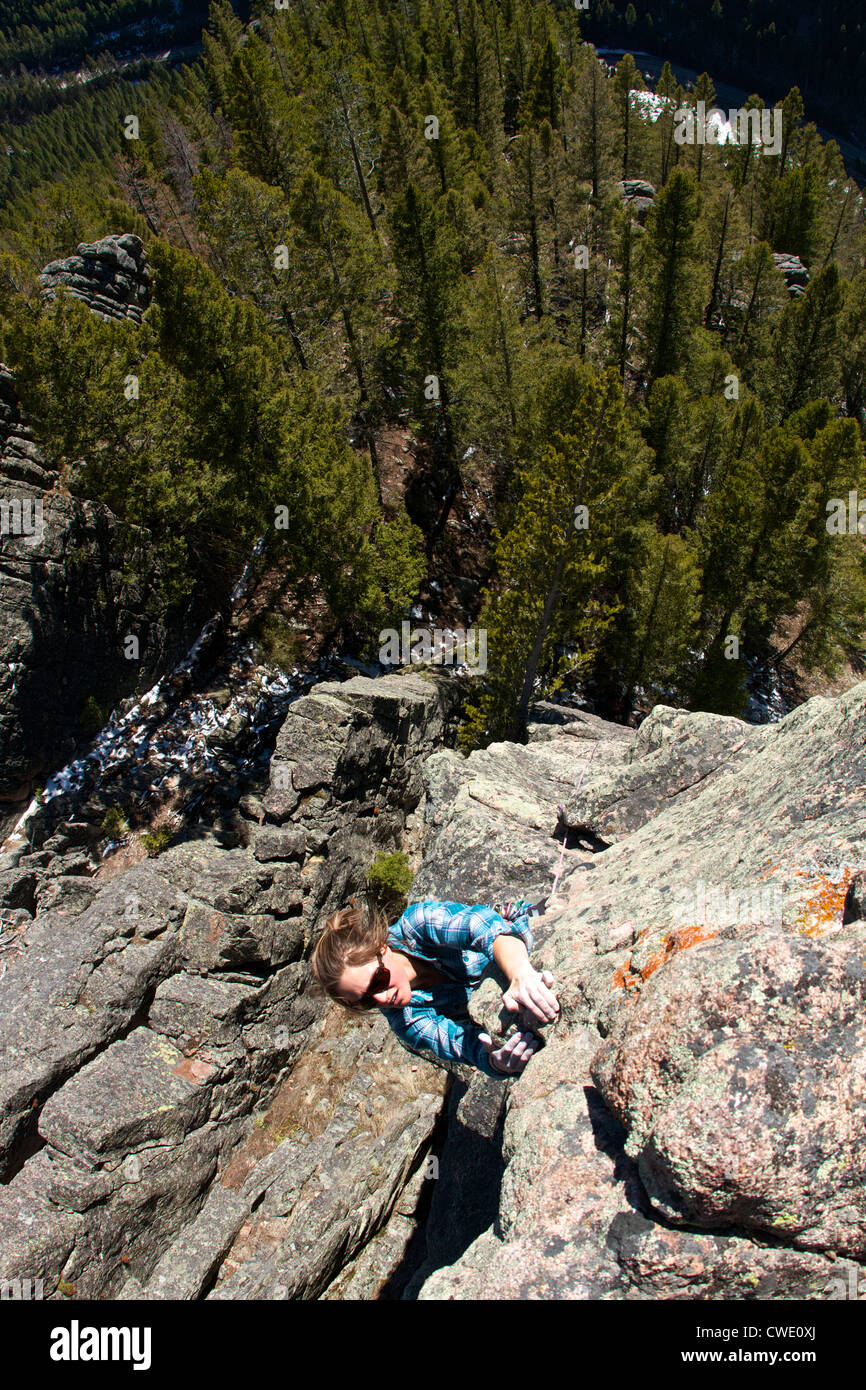 A female rock climbing on a warm spring day, as the last bit of winter ...