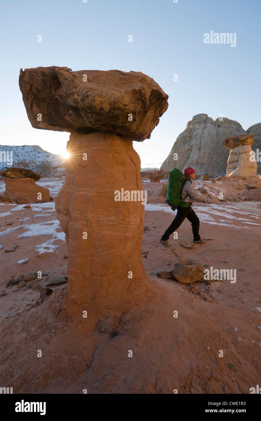 A woman hiking next to strange sandstone formations called the Rimrock ...